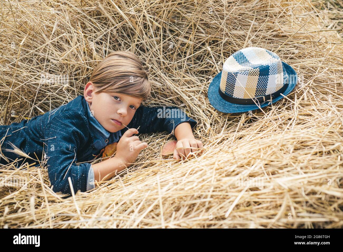 Kid on an autumn holiday in the farm. Bye summer - hi autumn. Kid boy ...