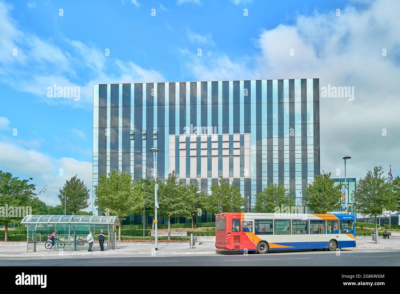 Bus at the bus stop outside The Cube modern Council building at the ...