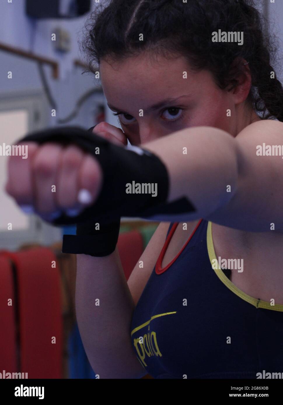 Young Spanish female boxer training in the gym boxing throwing a fist ...