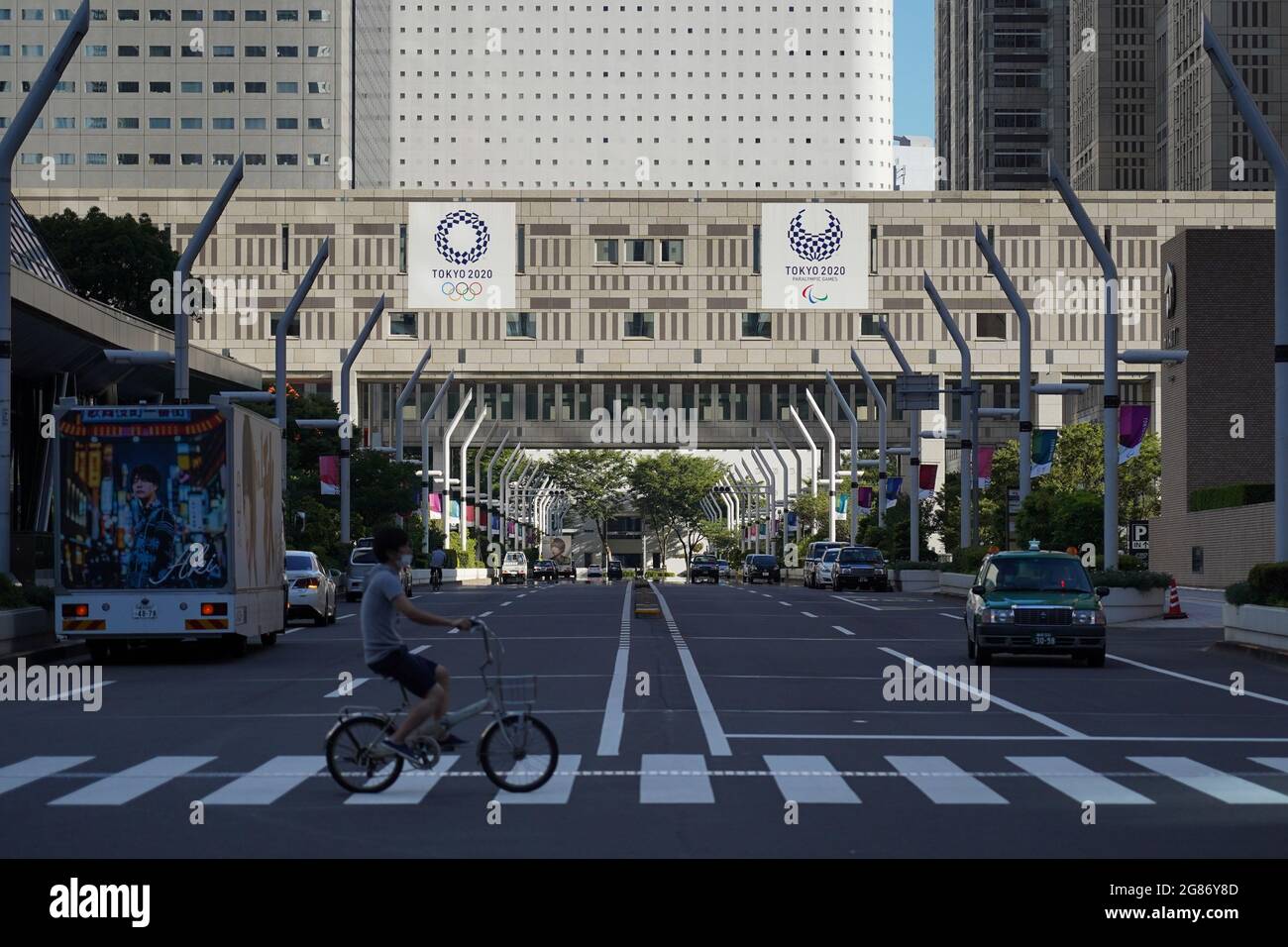 A man riding a bicycle crosses a road near Tokyo Metropolitan ...