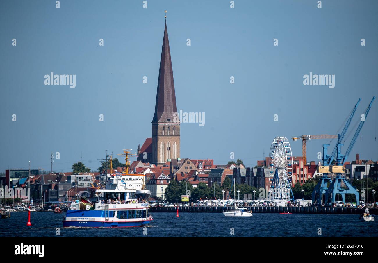 Rostock, Germany. 17th July, 2021. Ships sail in front of the city ...