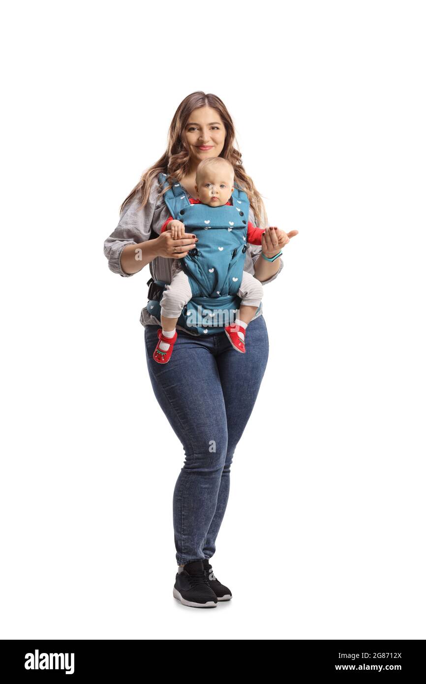 Full length portrait of a mother with a baby in a carrier smiling at ...