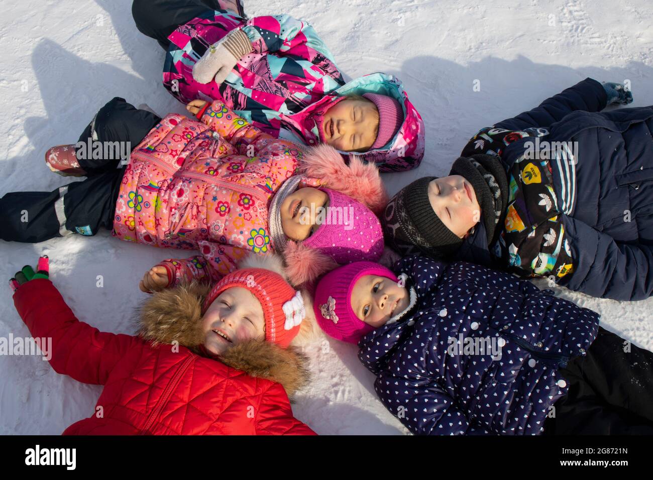 little children lying together in snow, flat lay Stock Photo - Alamy