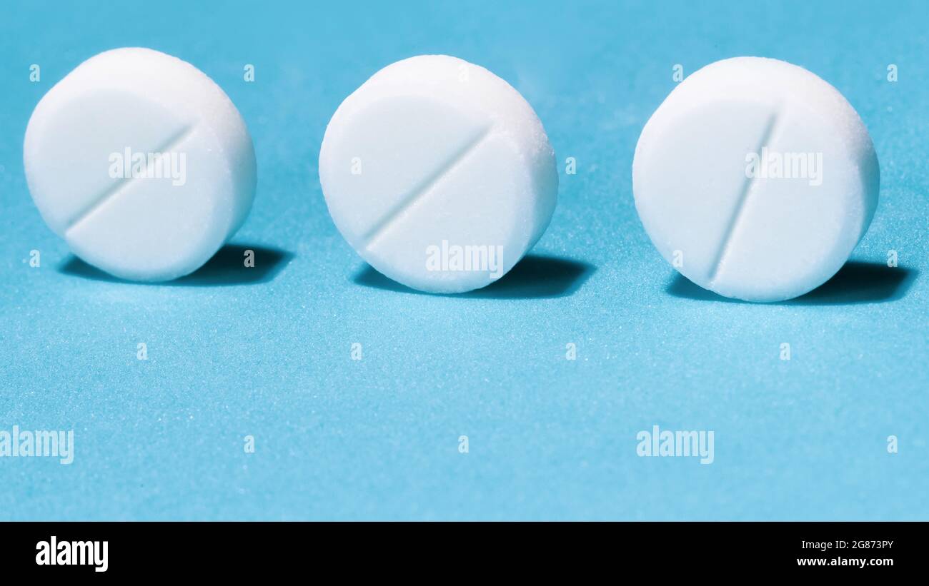 close up. three round tablets on a blue background. photo with a copy ...