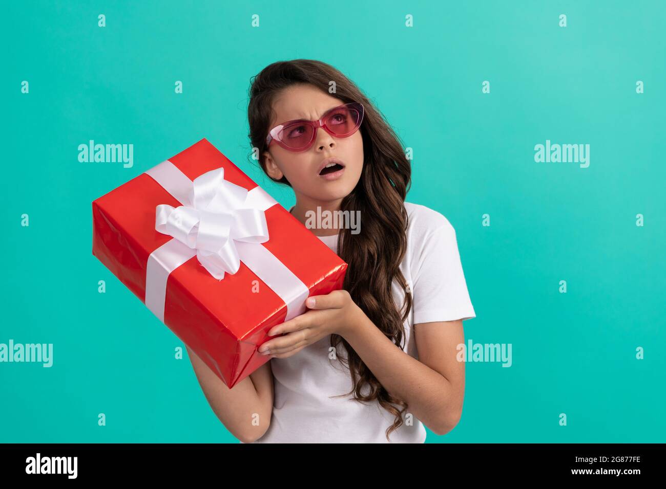 fashionable curious kid in sunglasses hold gift box, curiosity Stock ...
