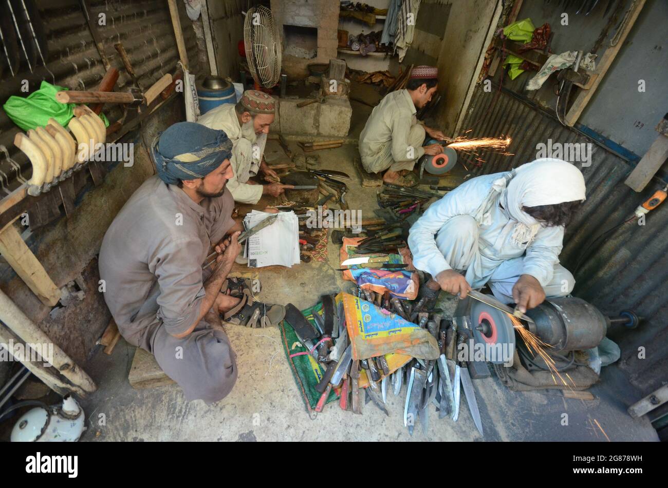 Peshawar, Pakistan. 17th July, 2021. A Pakistani vendor sharpen axe ...