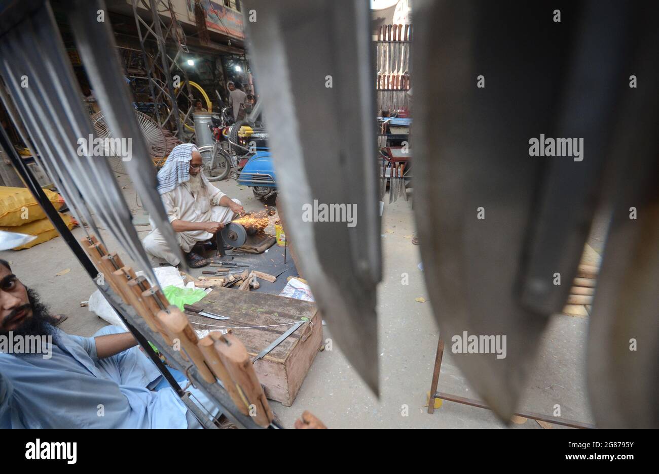 Peshawar, Pakistan. 17th July, 2021. A Pakistani vendor sharpen axe ...