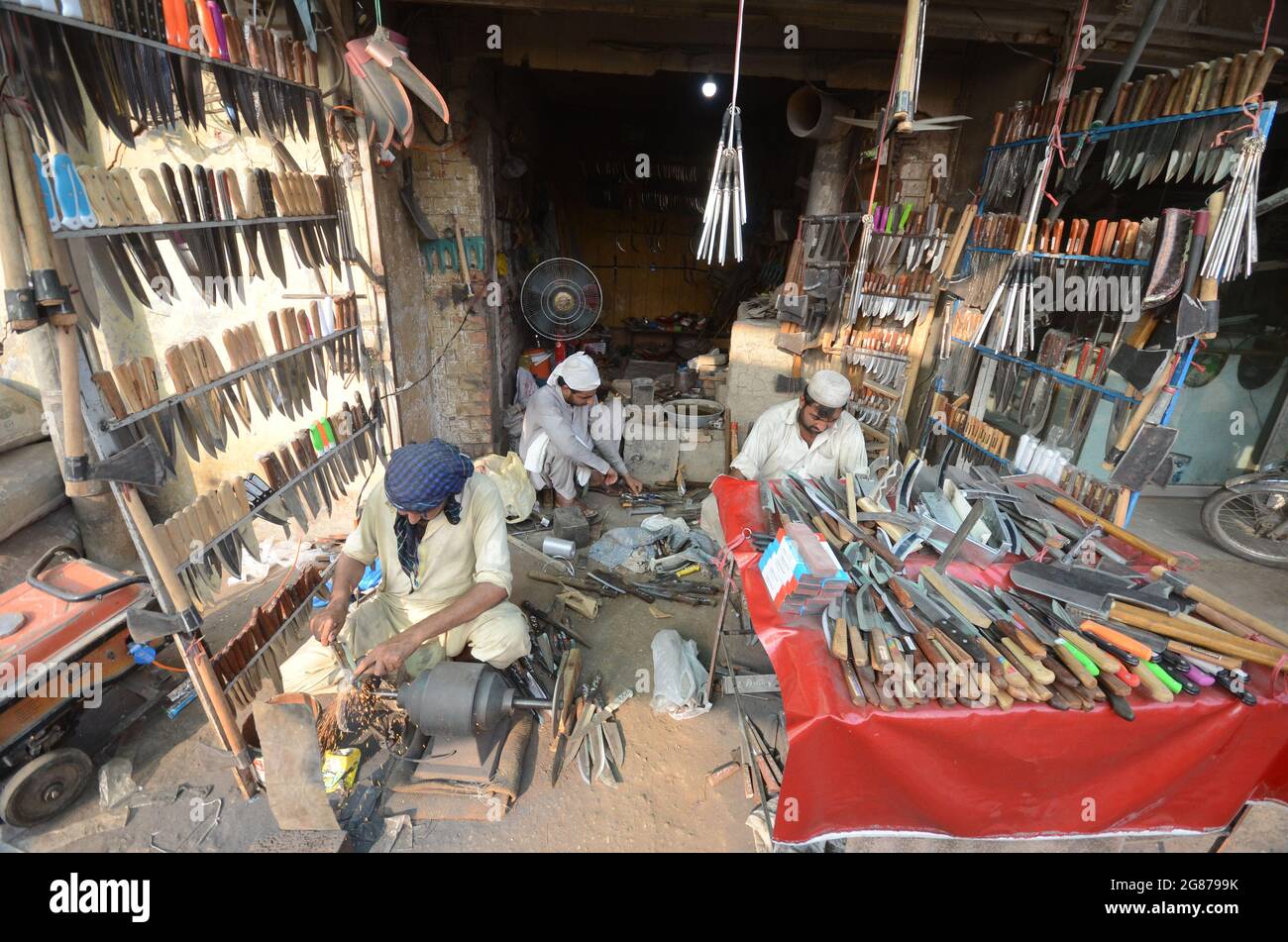 Peshawar, Pakistan. 17th July, 2021. A Pakistani vendor sharpen axe ...