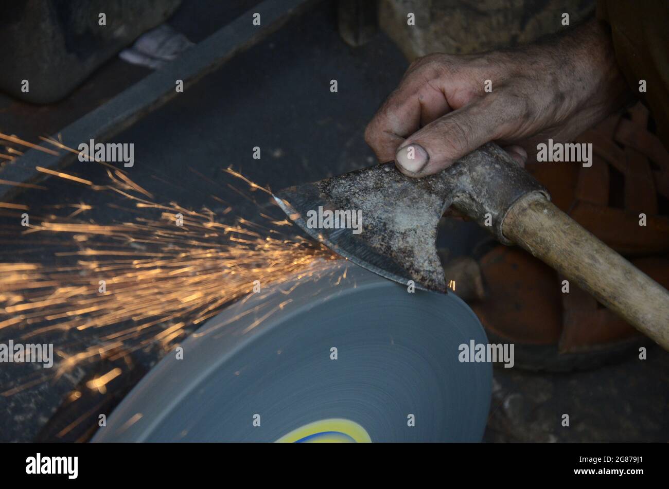 Peshawar, Pakistan. 17th July, 2021. A Pakistani vendor sharpen axe ...