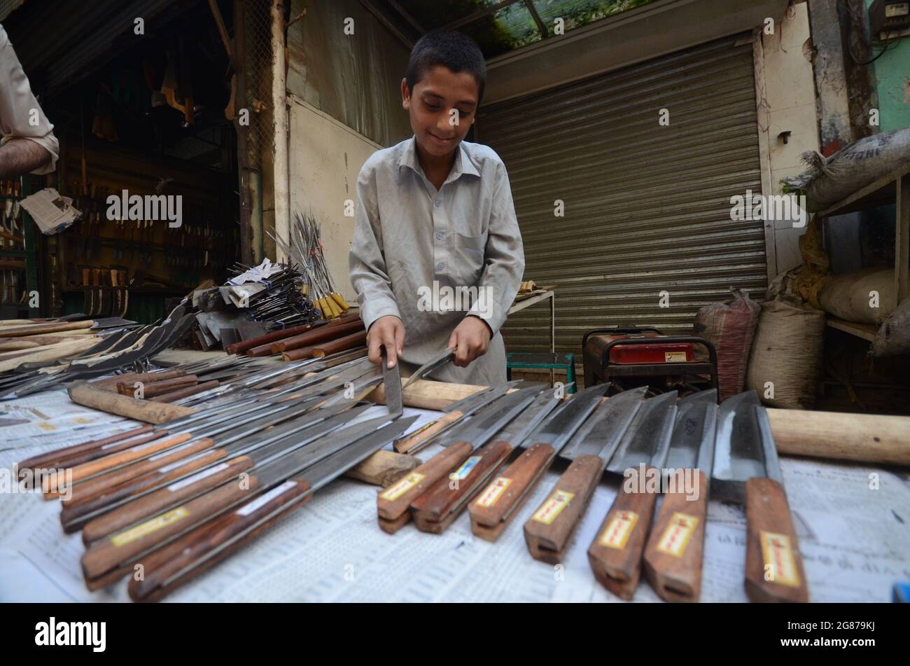 Peshawar, Pakistan. 17th July, 2021. A Pakistani vendor sharpen axe ...