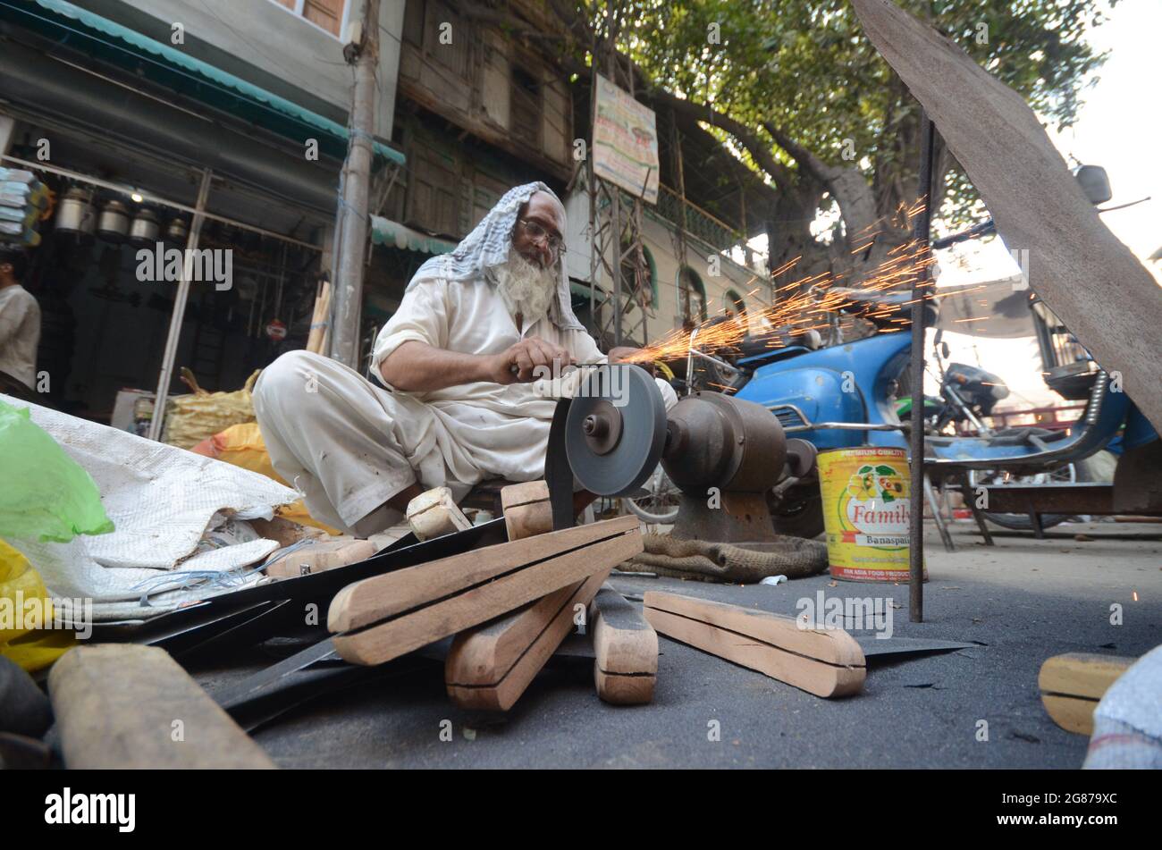 Peshawar, Pakistan. 17th July, 2021. A Pakistani vendor sharpen axe ...