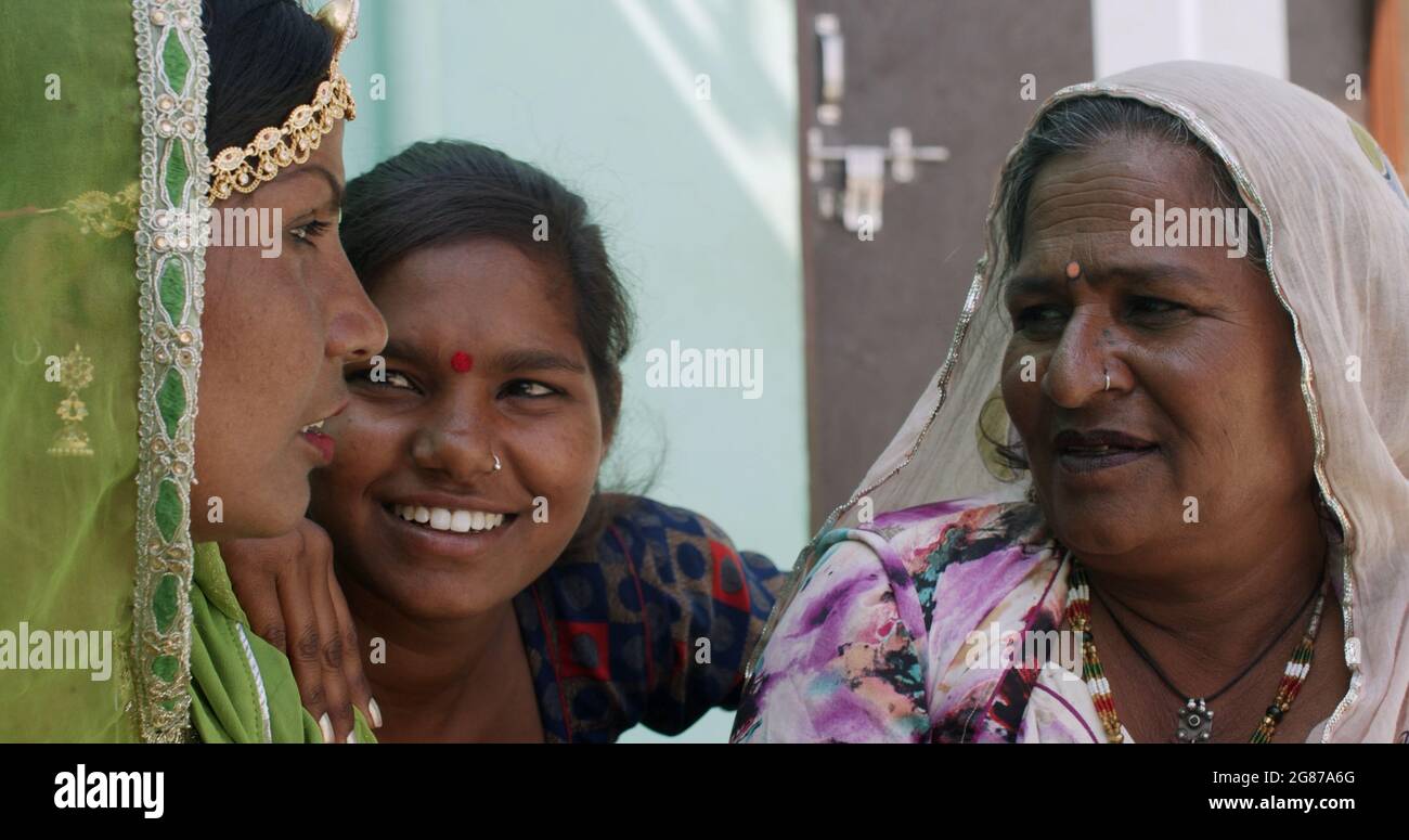 Three generations of South Asian women in traditional clothing having a ...