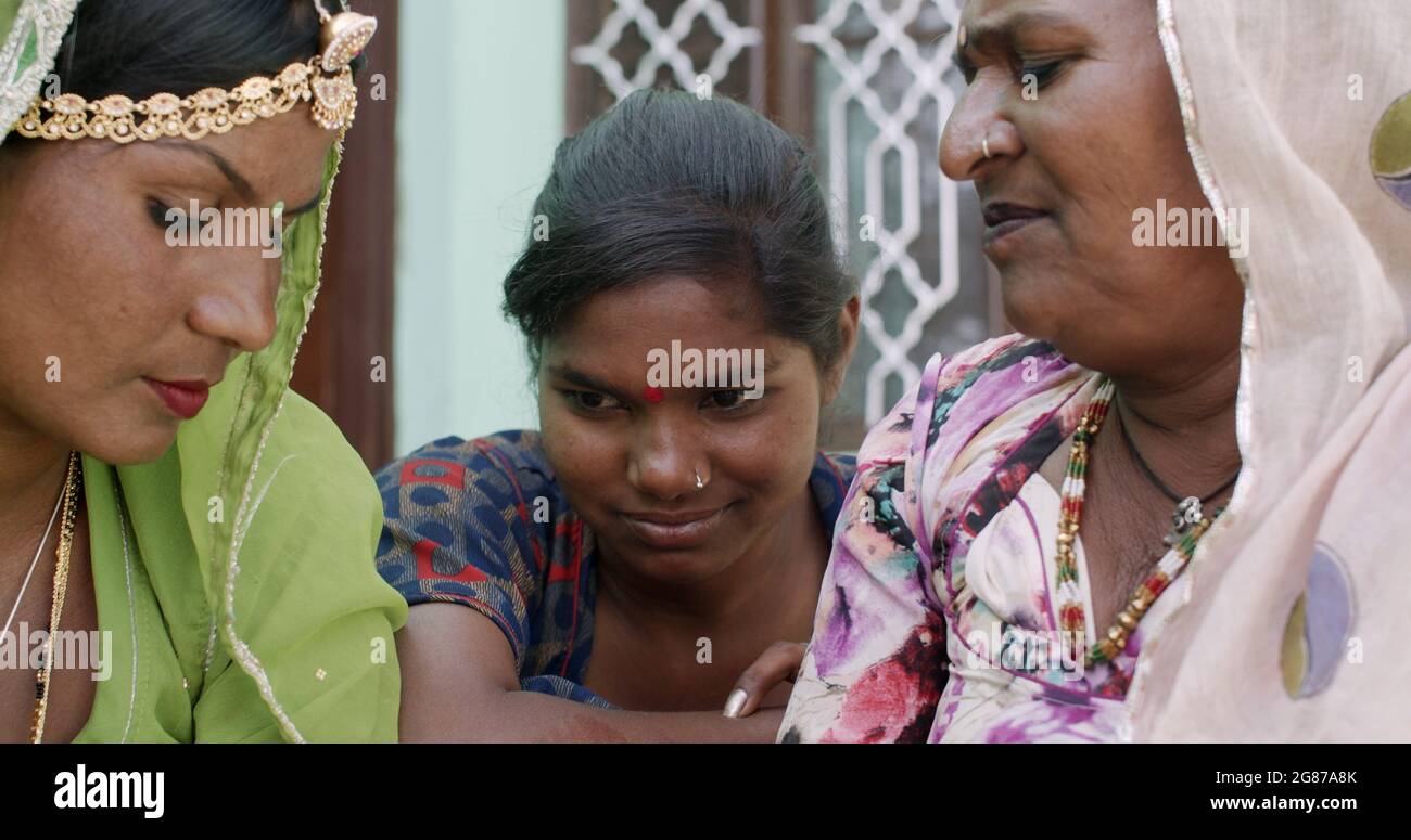 Three generations of South Asian women in traditional clothing having a ...