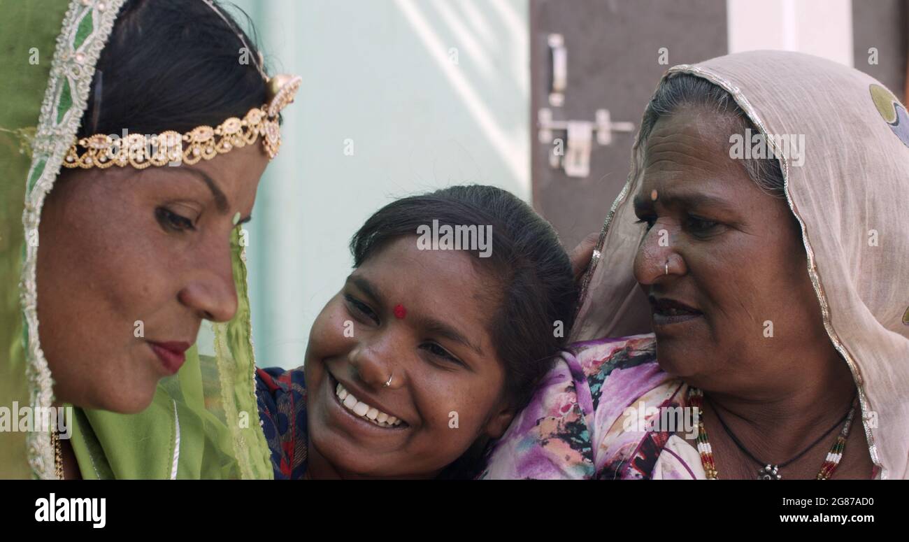 Three generations of South Asian women in traditional clothing having a ...