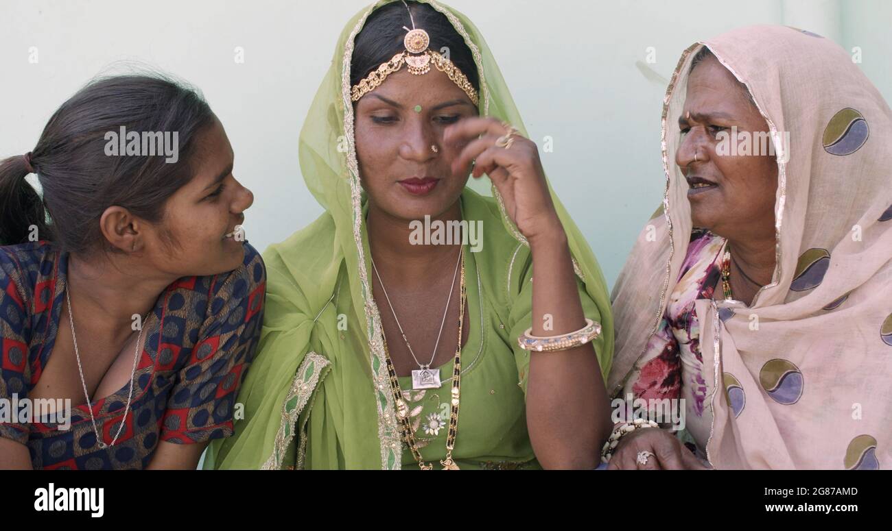 Three generations of South Asian women in traditional clothing having a ...