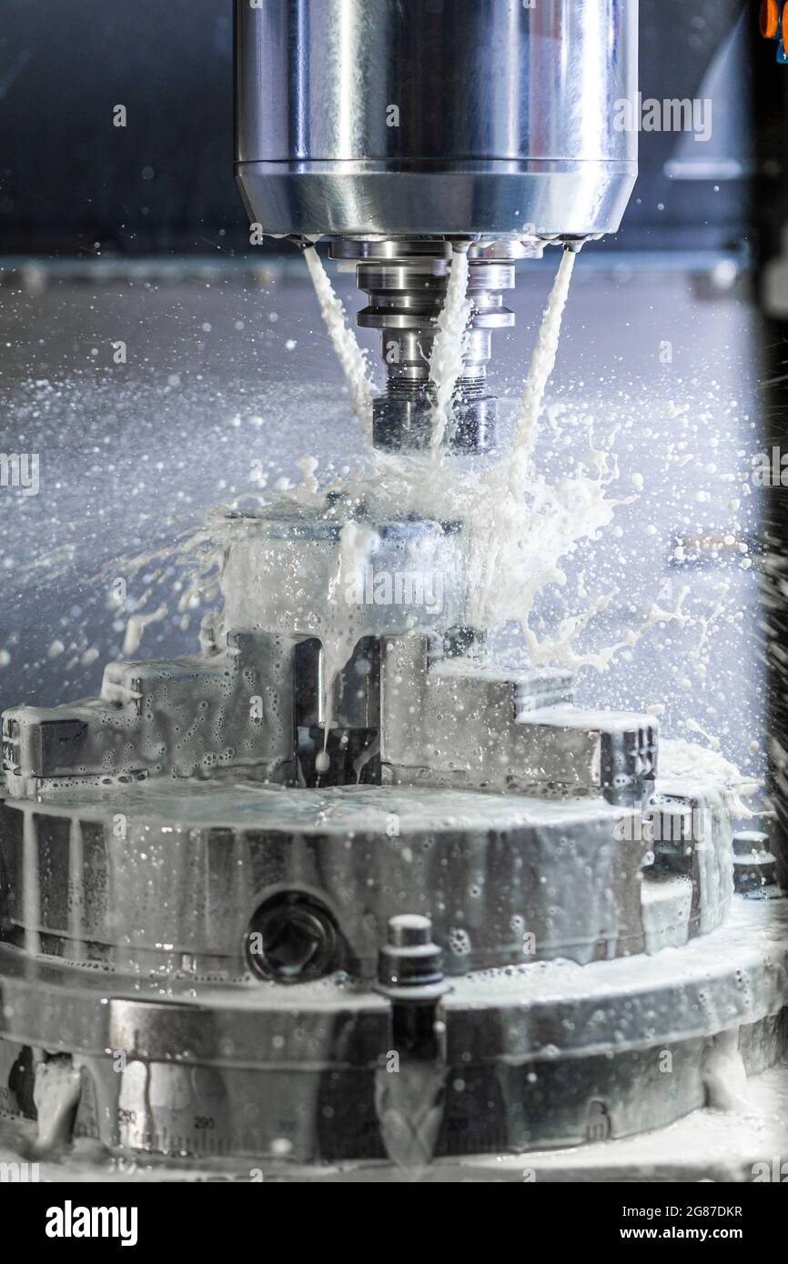Vertical photo of industrial wet milling process in 5-axis cnc machine ...