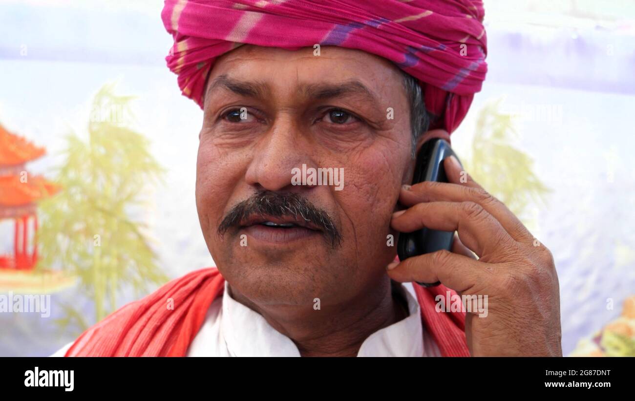 Indian male in traditional clothes talking on a phone Stock Photo - Alamy