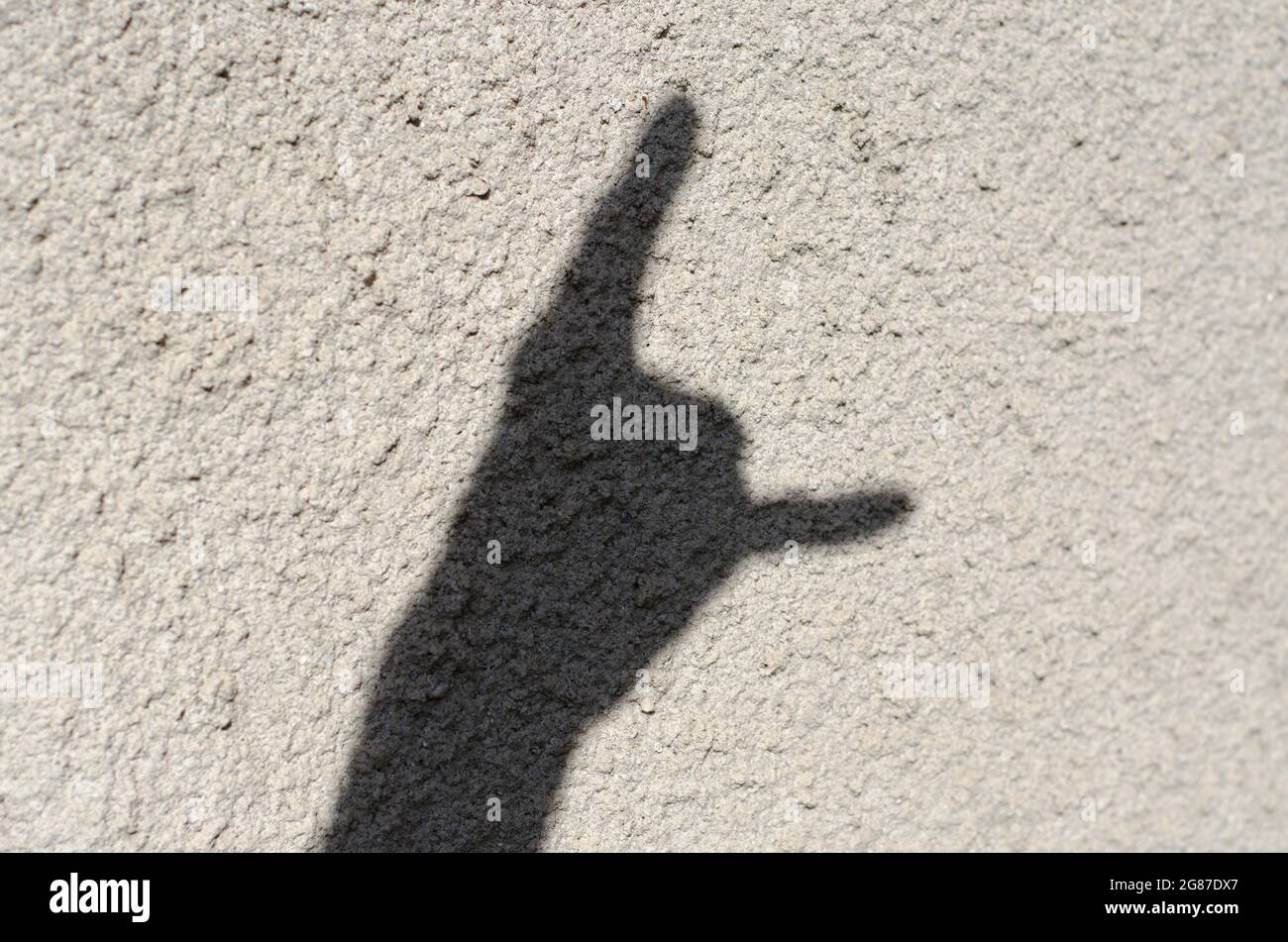 The shadow on the wall is a gesture of punks. man gesturing rock and ...