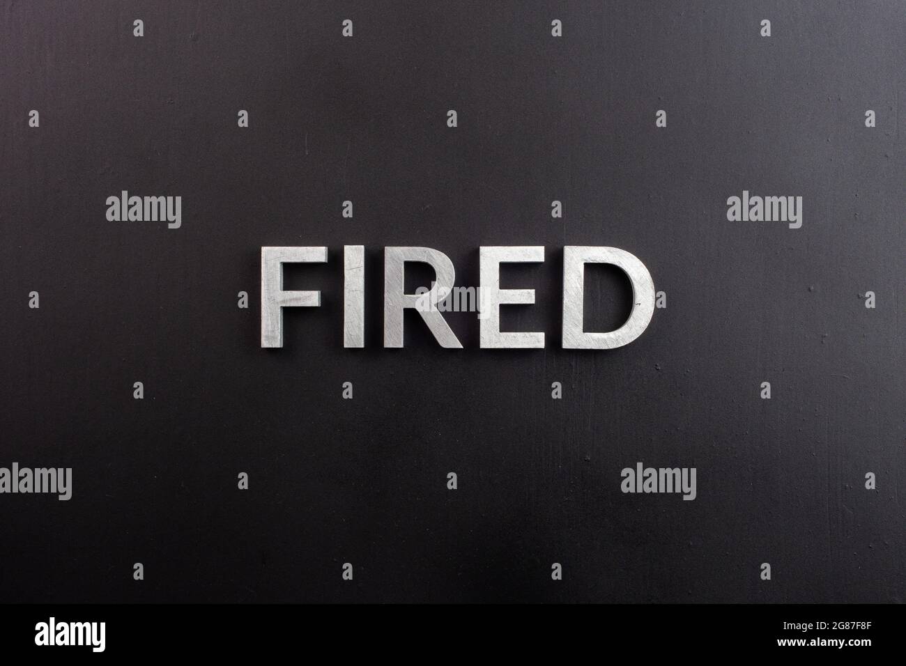 the word fired laid with white brushed metal letters on flat black ...