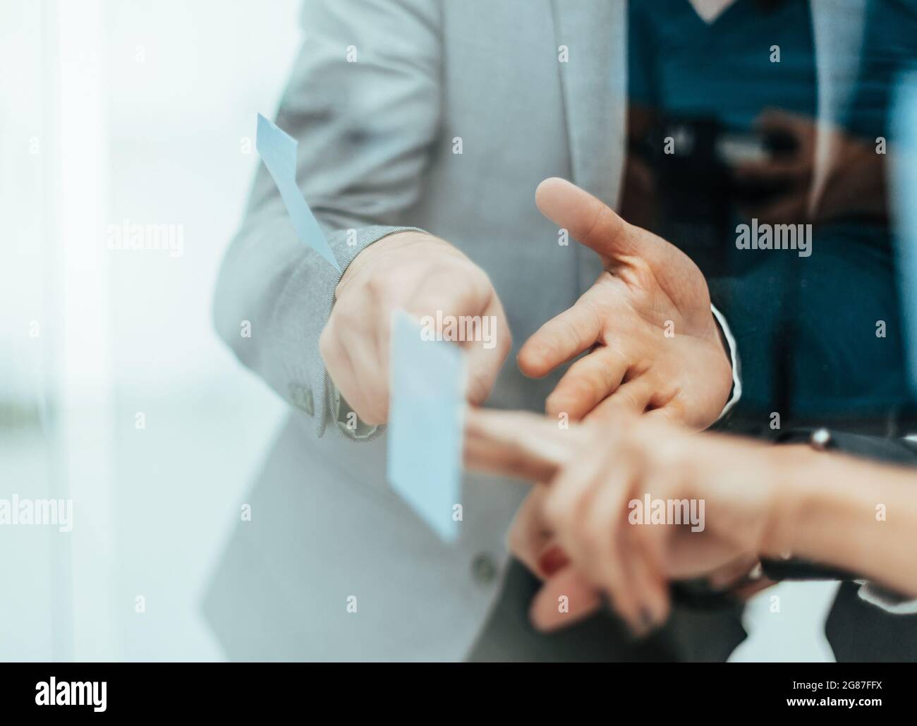 close up. employees discussing a sticky note on the glass Stock Photo ...