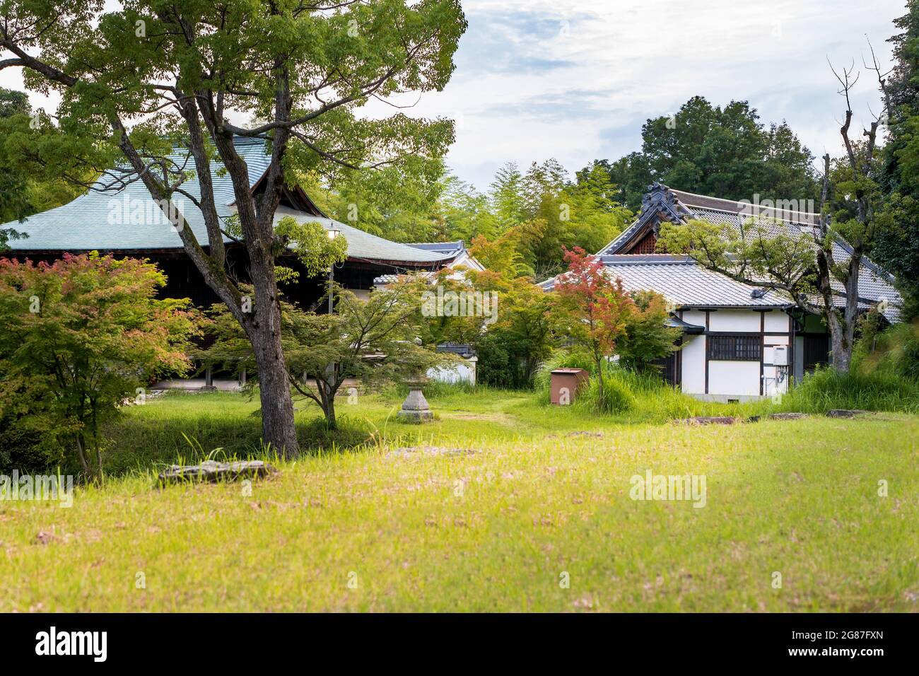 Grassy clearing in front of quiet temple and residence Stock Photo - Alamy