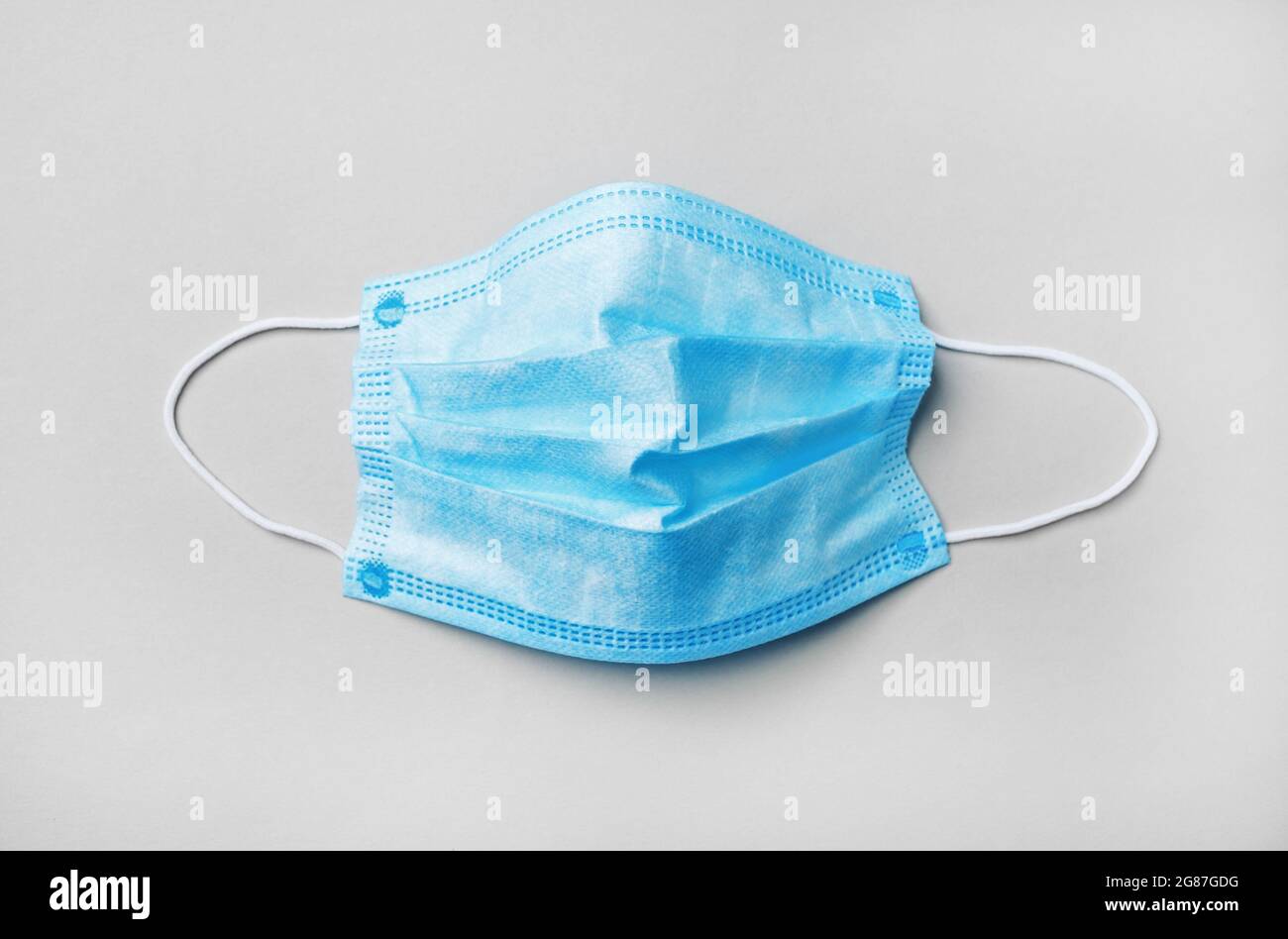 Blue medical face mask on paper background. Flat lay Stock Photo - Alamy