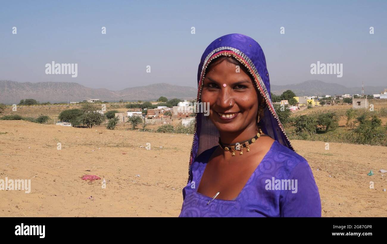 Young Indian female in purple traditional clothes in an outdoor place ...