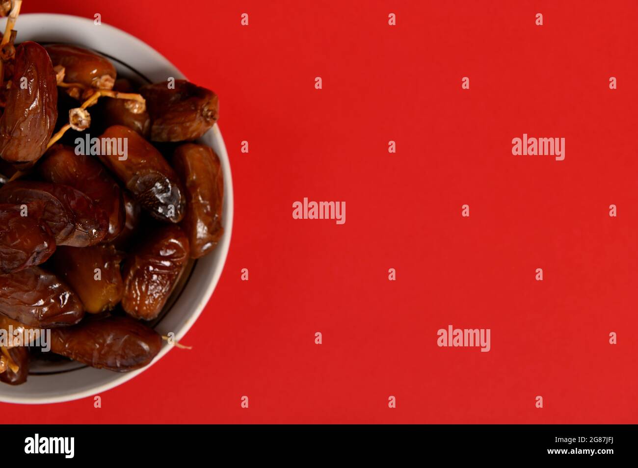 Cropped image of a plate with delicious fresh dates. Red background ...