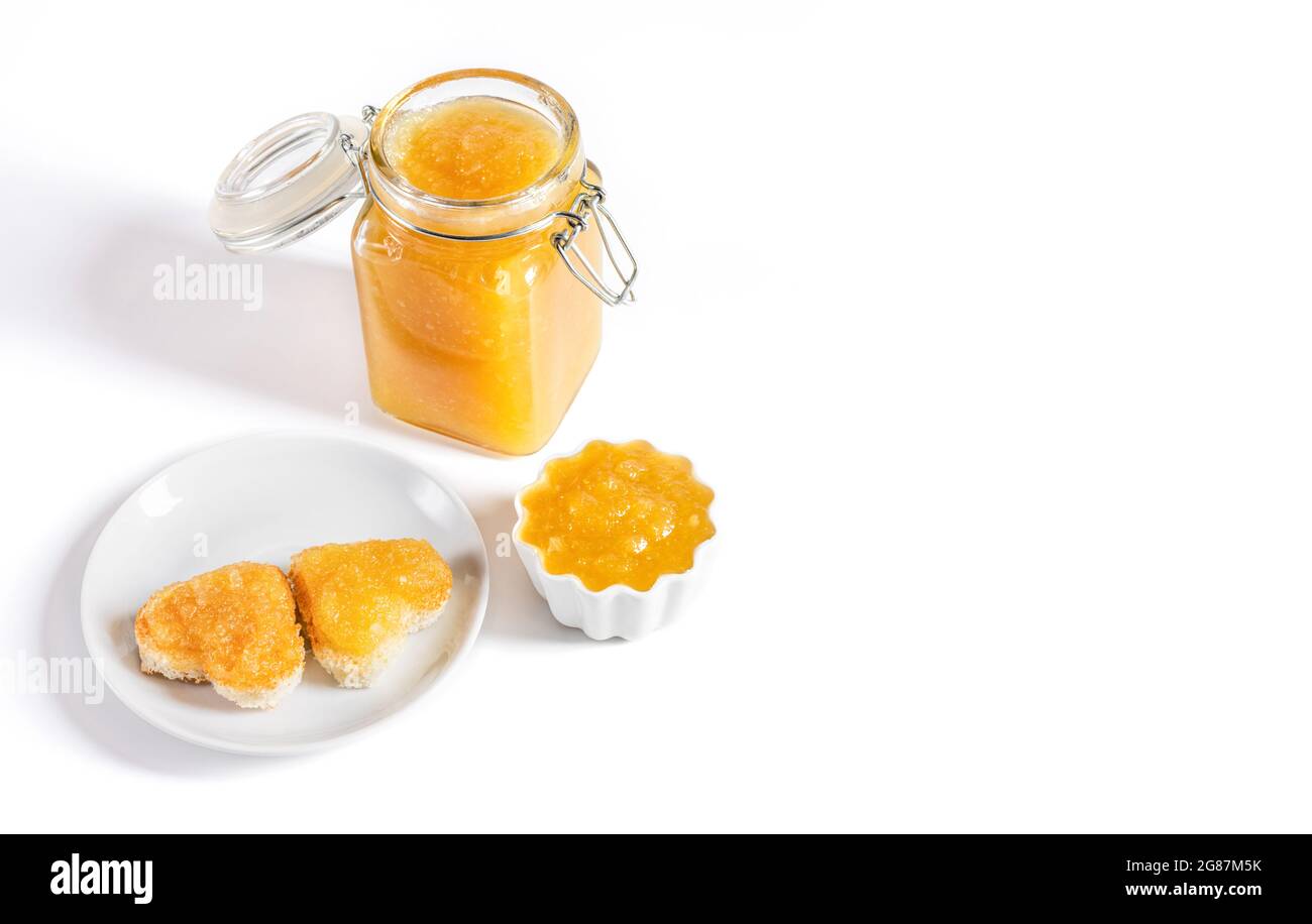 Yellow jam and toast hearts on a white background. Fruit confiture in a ...