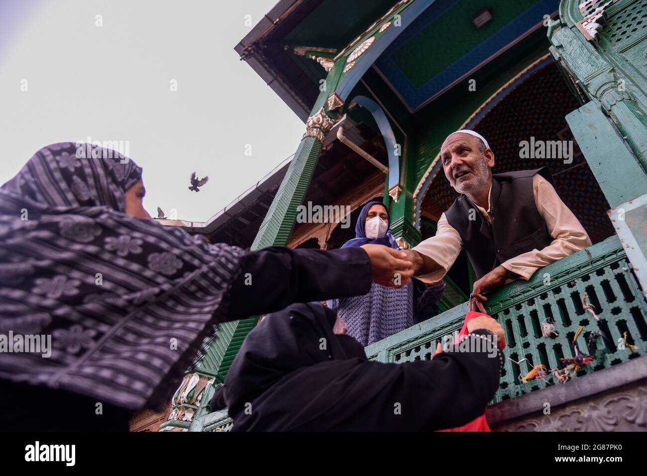 A Kashmiri Muslim man distribute sweets among devotees during urs of ...