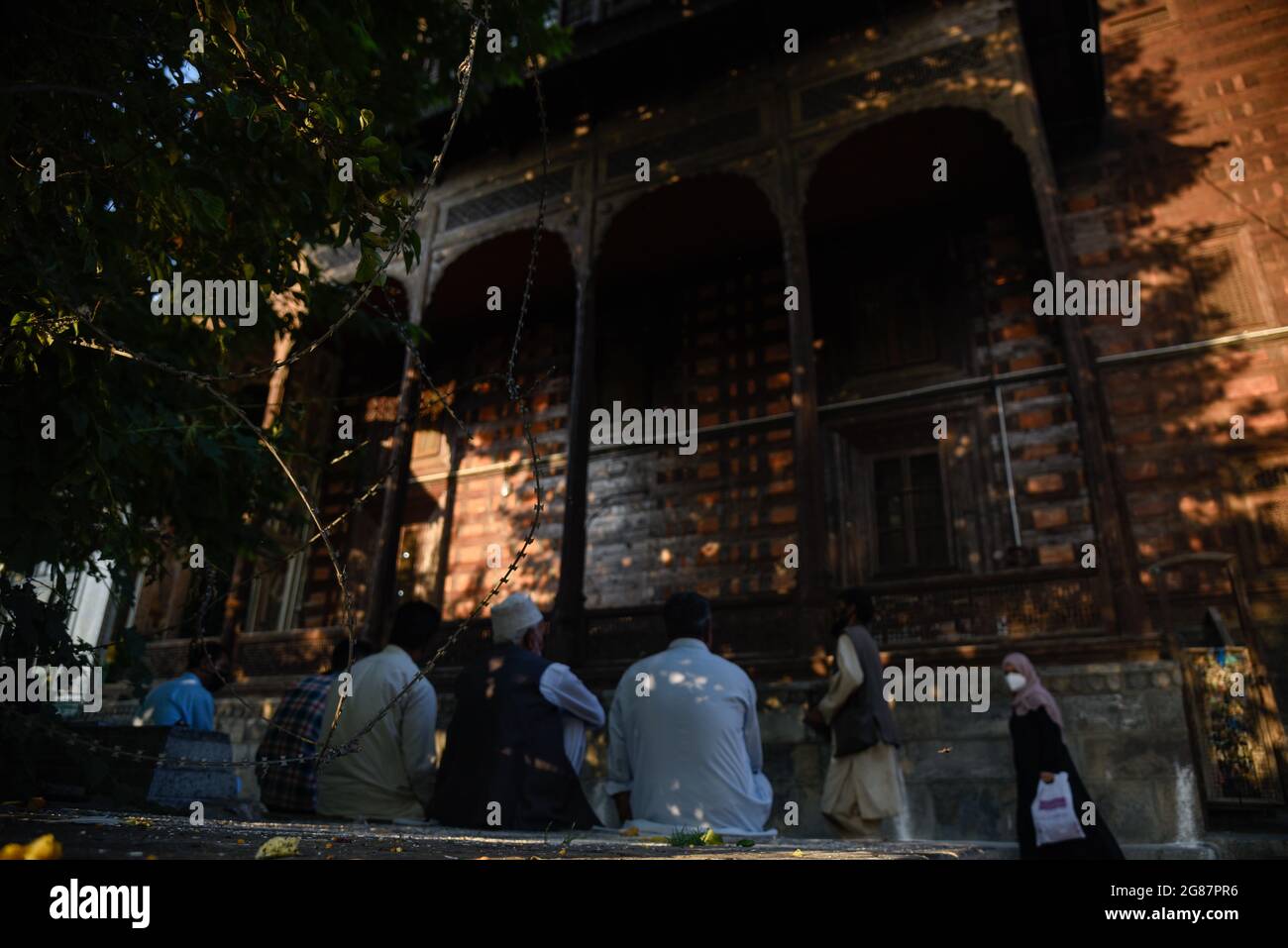 People sit outside the shrine of Sufi Saint Syed Ali Hamadani on his ...