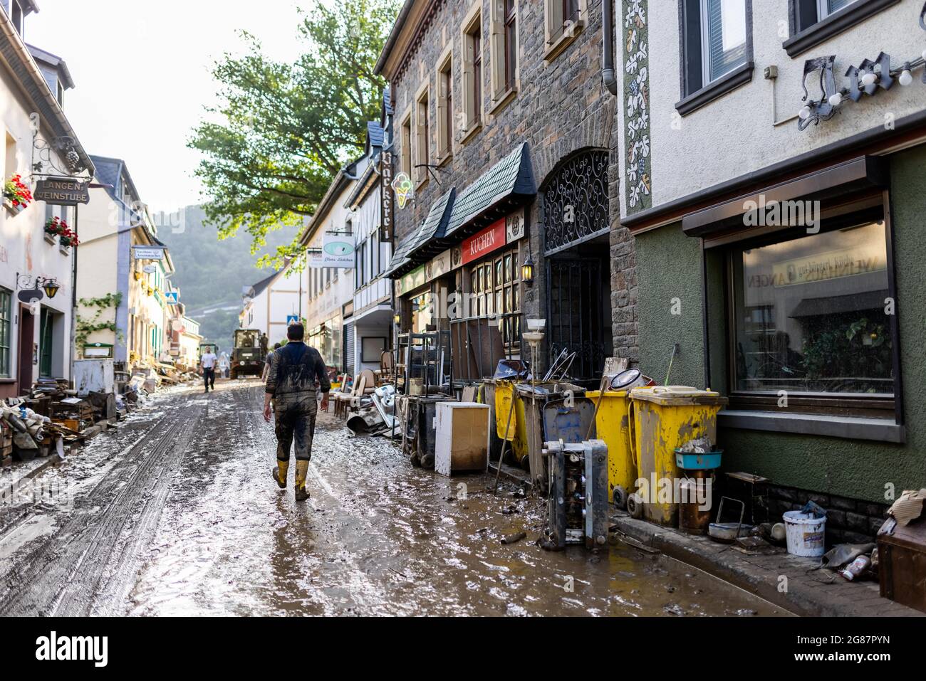 Altenahr, Germany. 17th July, 2021. A helper smeared with mud walks ...