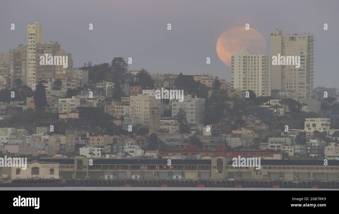 partial eclipse of full blood super moon setting over the outskirts of San Francisco, CA. in ...