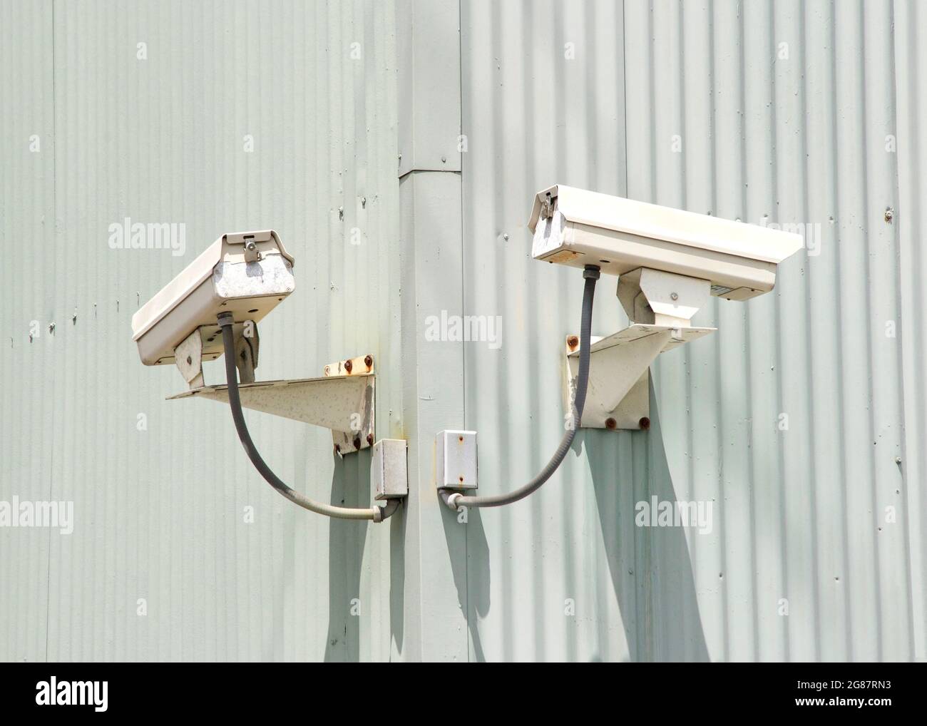 Security cameras on the corner of an industrial building. Hard wired ...