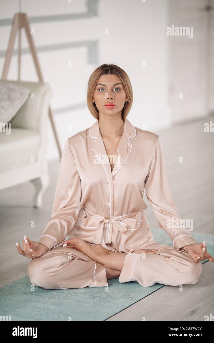 Beautiful lady is meditating on floor in her bedroom Stock Photo - Alamy