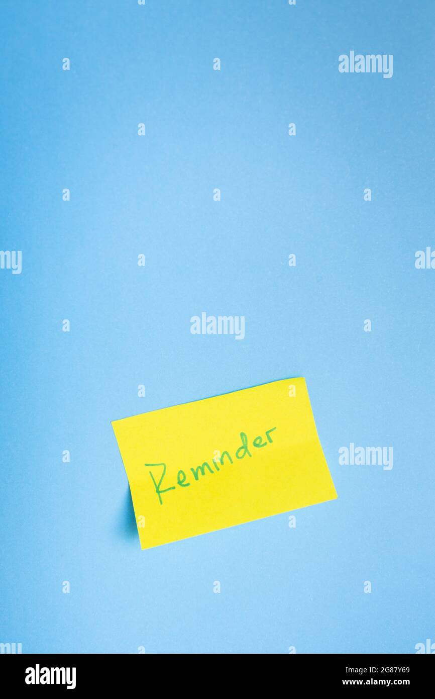 Reminder Yellow adhesive note on blue light background. Minimalist ...