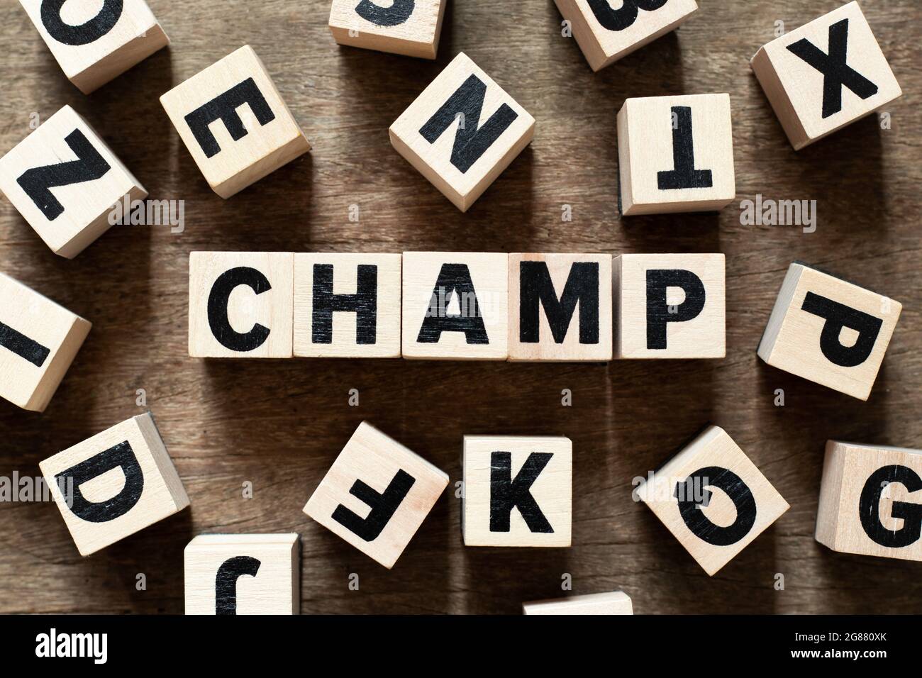 Wood letter block in word champ on wood background with another ...
