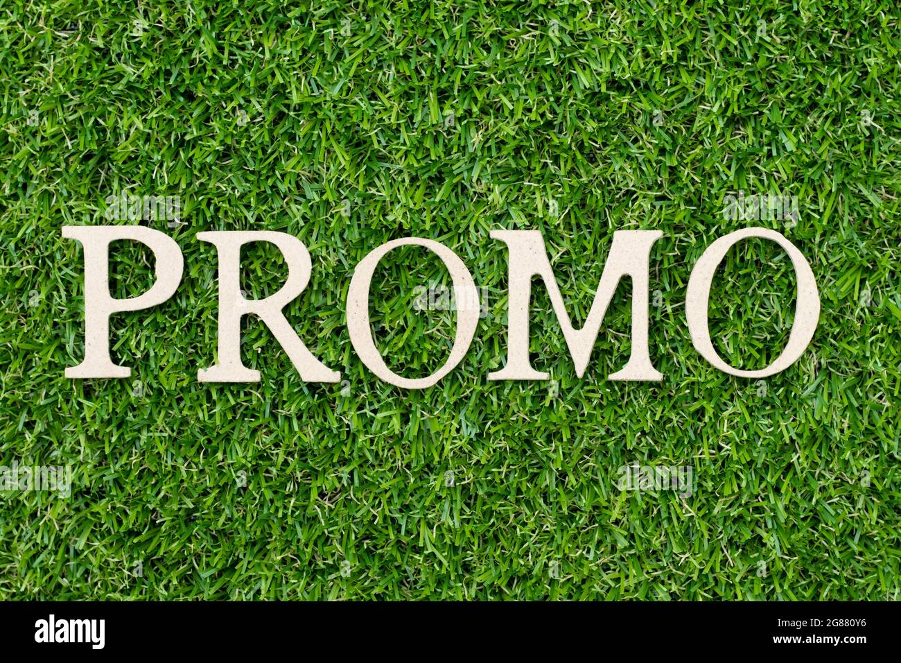 Wood alphabet letter in word promo on green grass background Stock ...