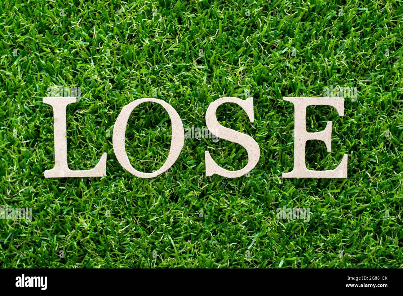 Wood letter in word lose on artificial green grass background Stock ...