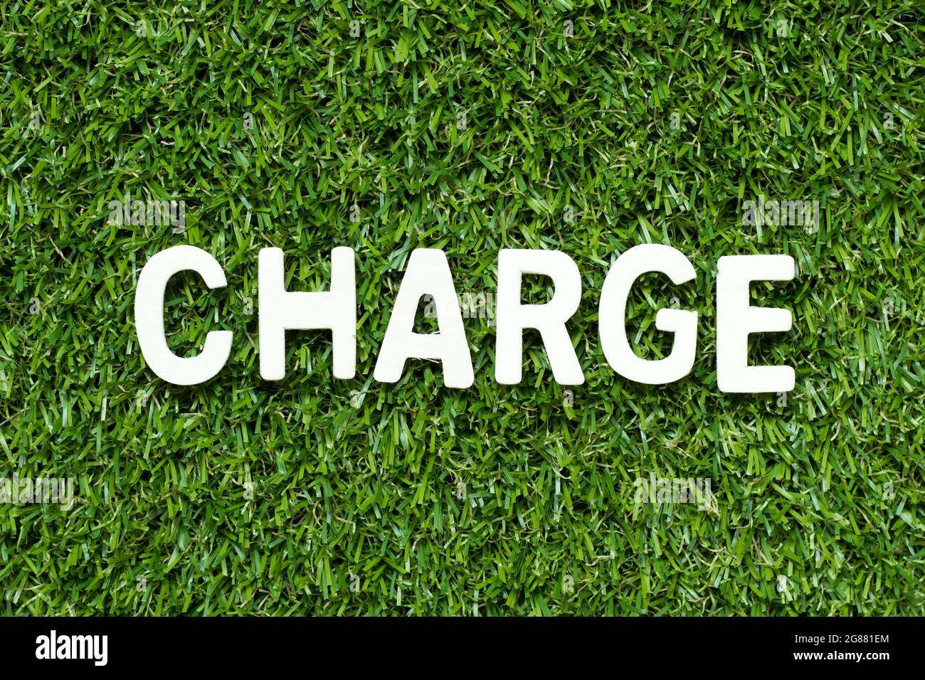 Alphabet letter in word charge on artificial green grass background ...