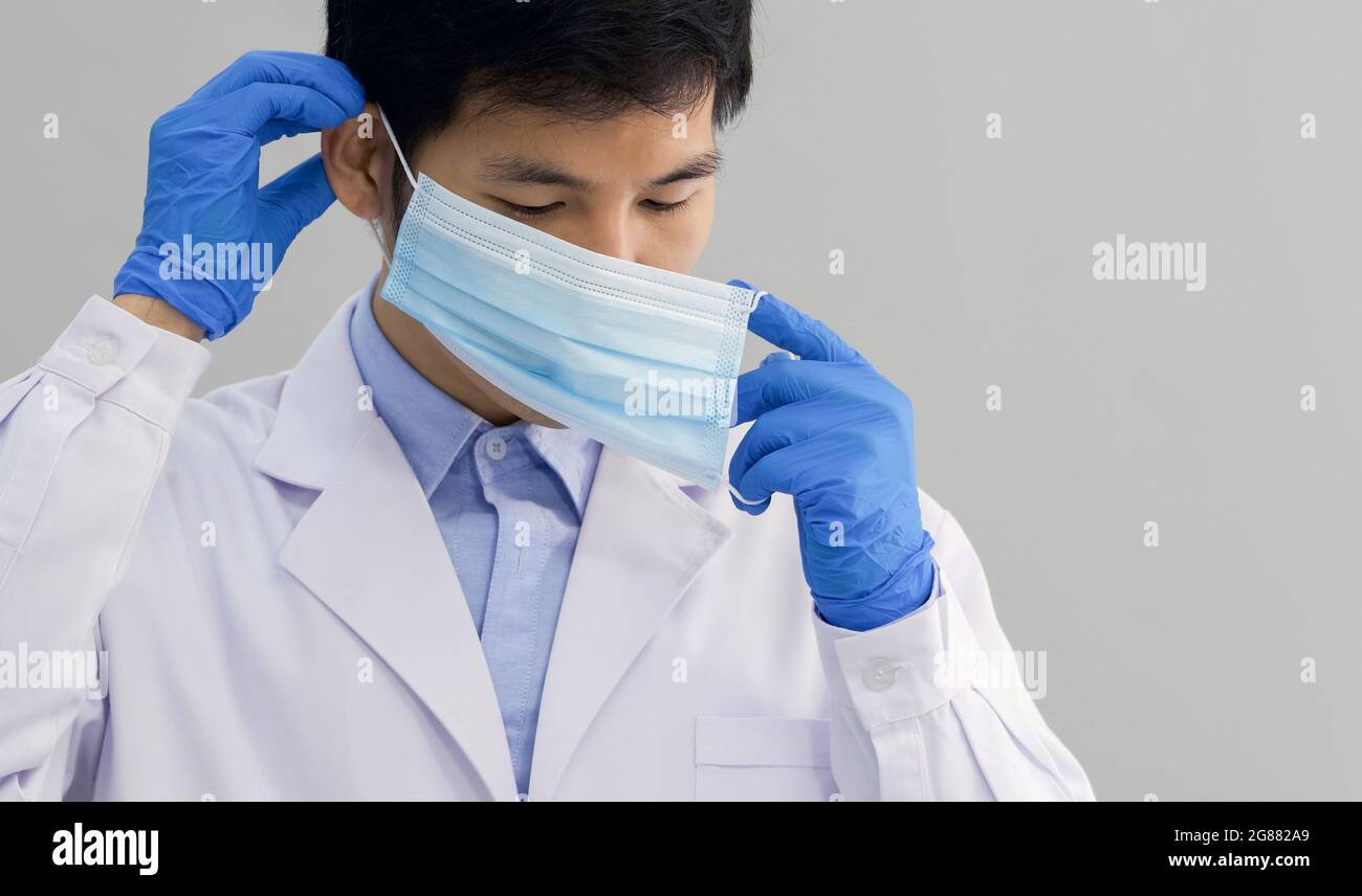 Asian scientist waring a face mask before beginning the experiment in a ...