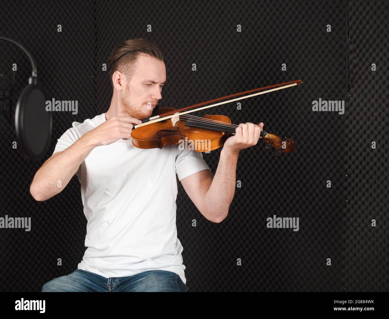 Portrait of handsome man musician plays the violin in the recording ...