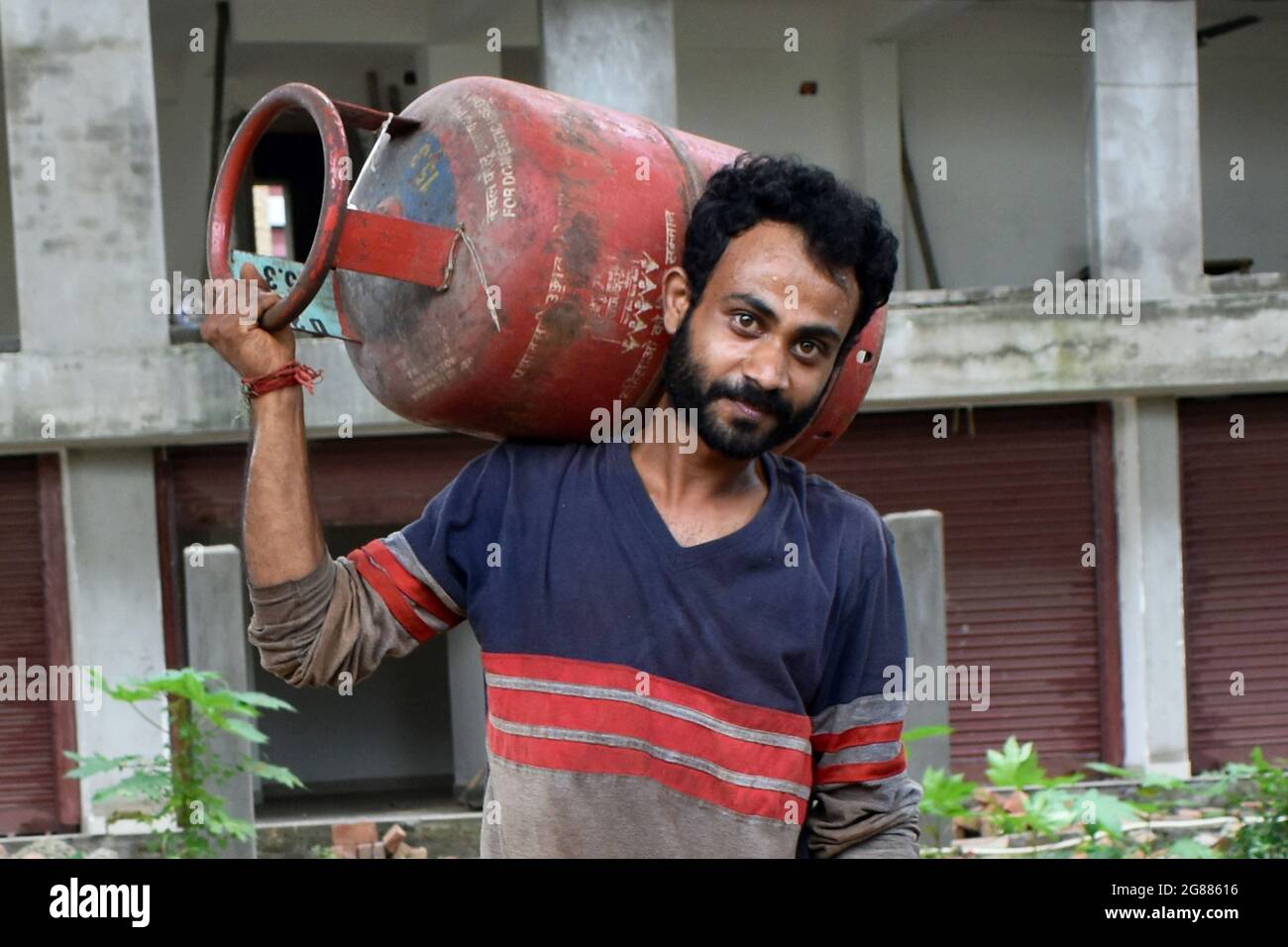 A person carrying Gas cylinder on his shoulder for delivery during the ...