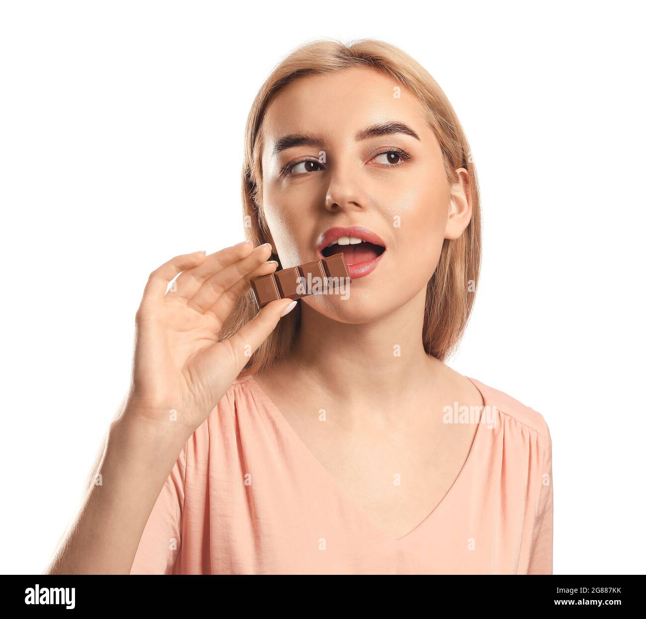 Beautiful young woman eating tasty chocolate on white background Stock ...
