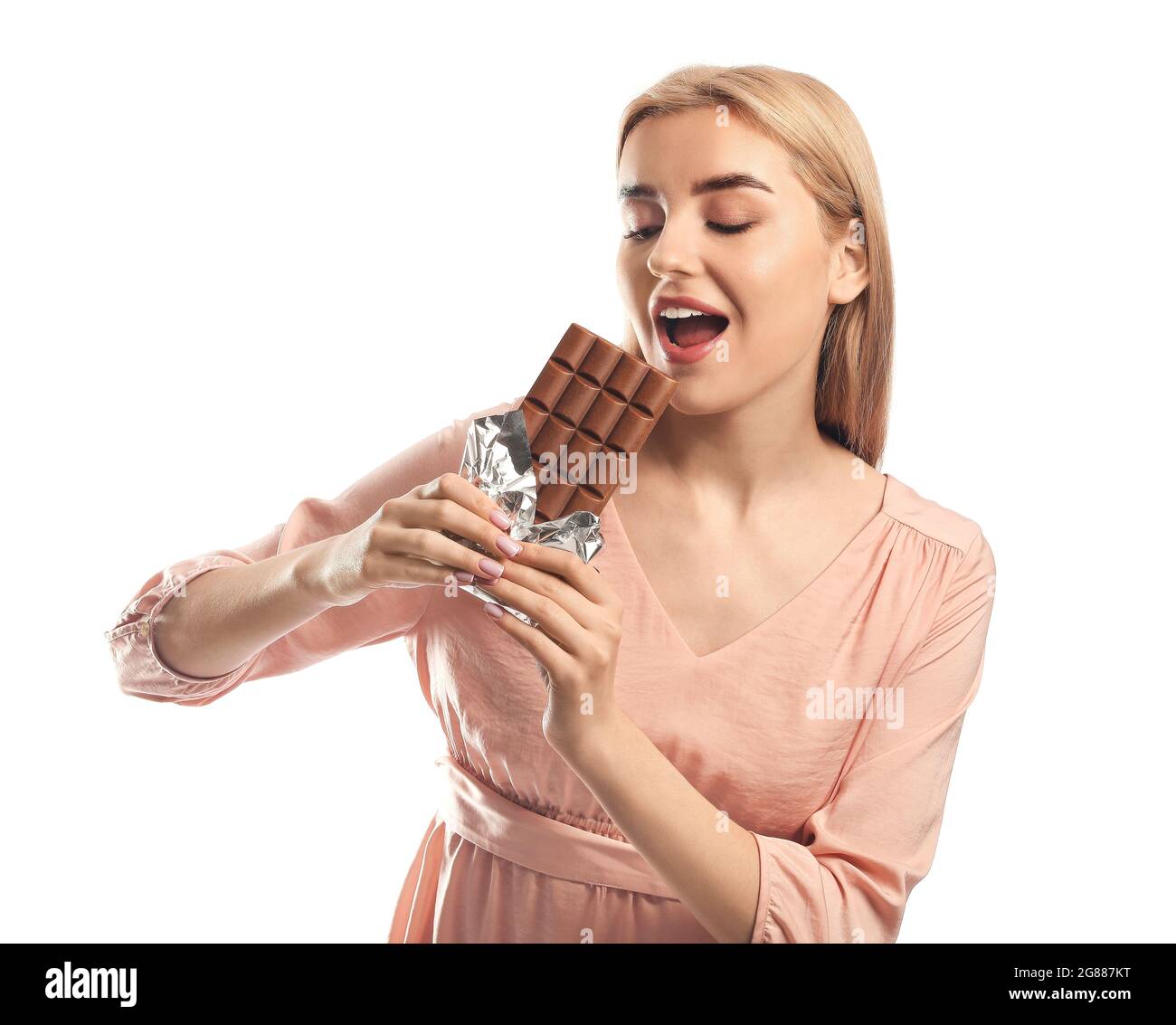 Beautiful young woman eating tasty chocolate on white background Stock ...