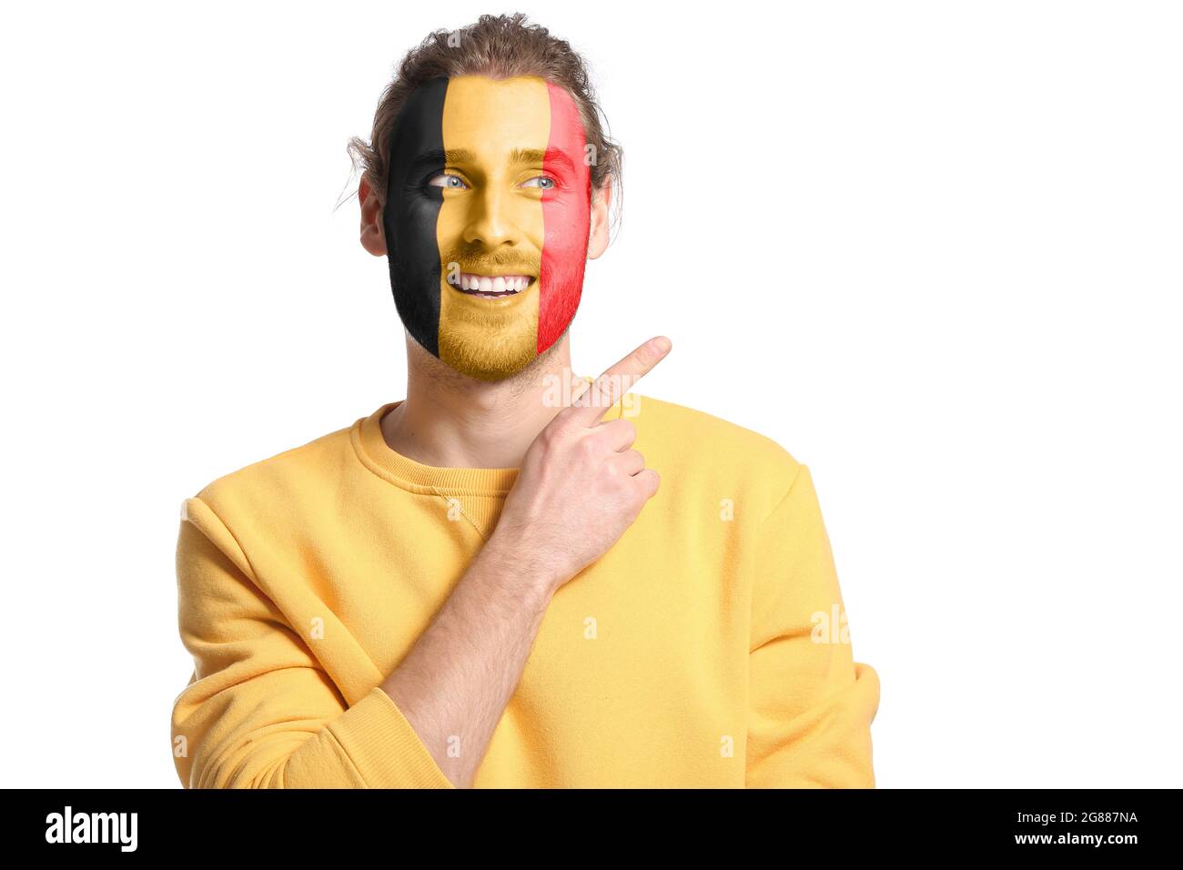 Young man with face in colors of Belgian flag pointing at something on ...