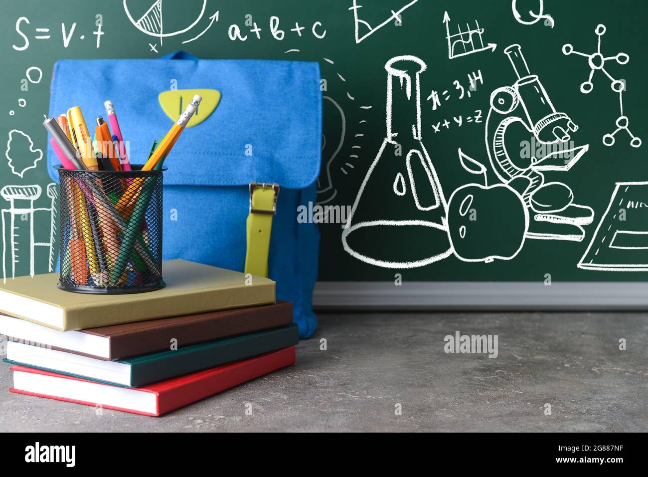 Books with schoolbag and stationery in classroom Stock Photo - Alamy