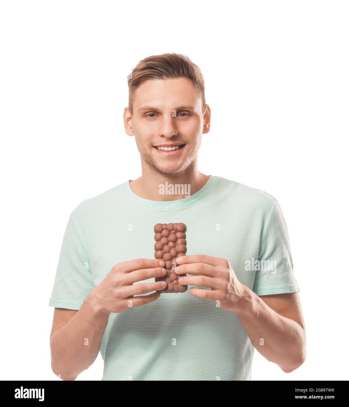 Handsome young man with tasty chocolate on white background Stock Photo ...