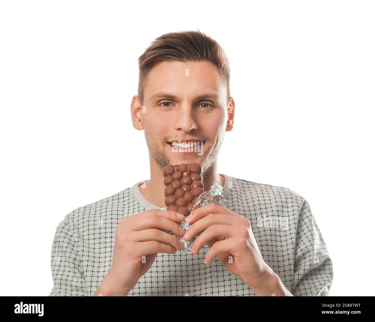 Handsome young man with tasty chocolate on white background Stock Photo ...
