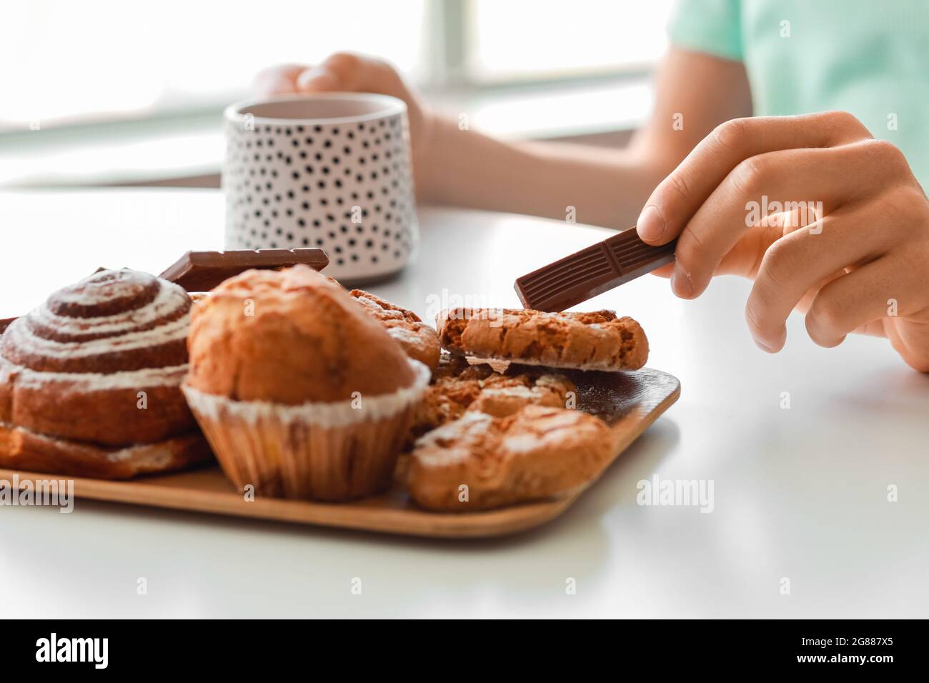 Young man eating sweets at home, closeup Stock Photo - Alamy